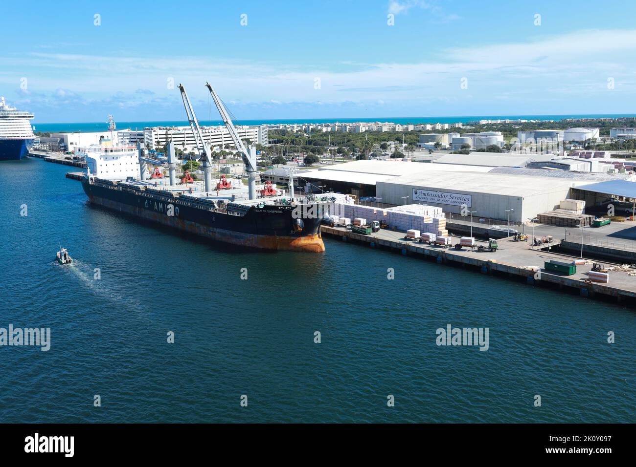 Large red Bulk ship / A coal ship docking outside big power station ...