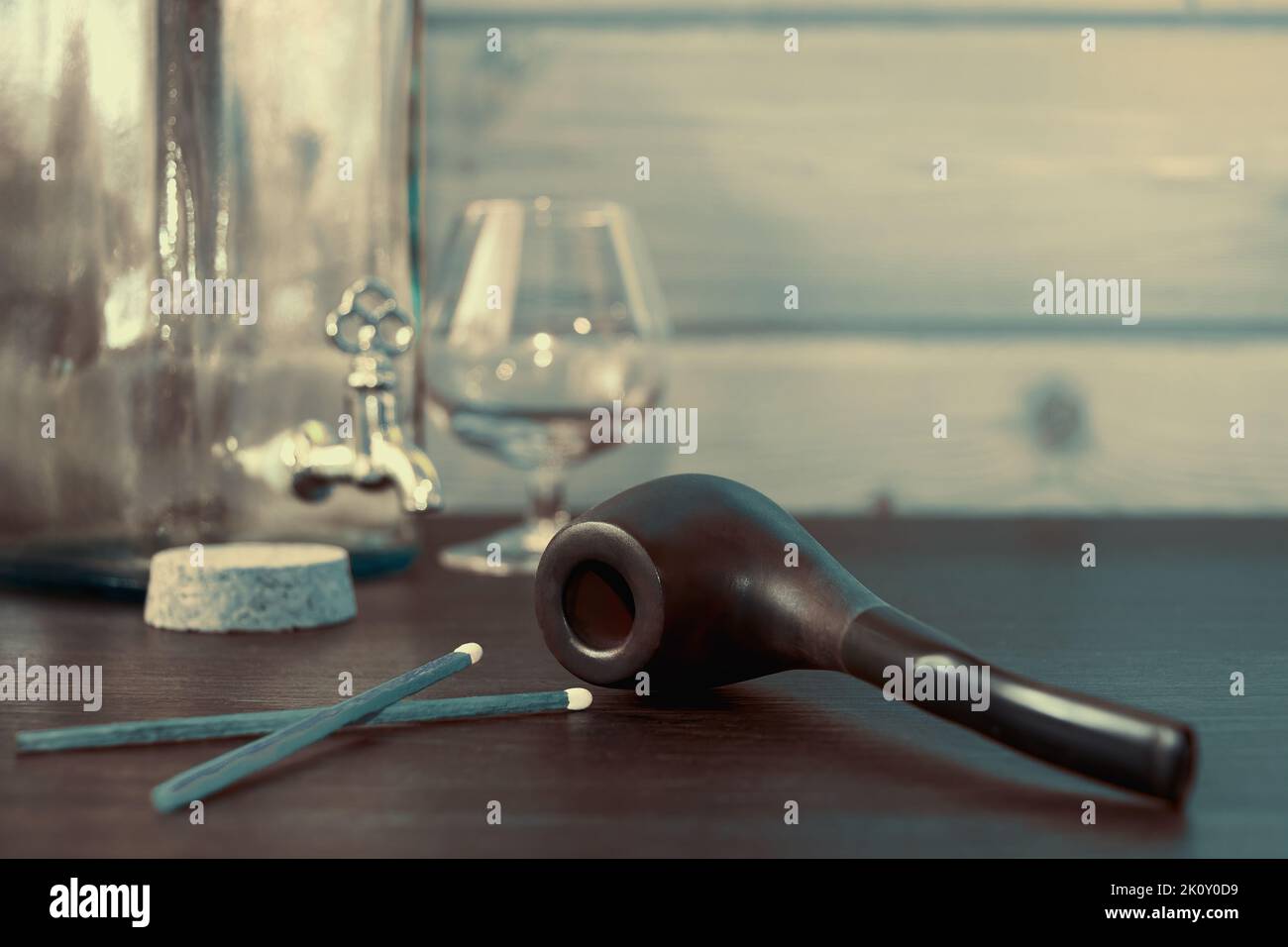 Toned image with smoking pipe, matches, wine glass and bottle. Alcohol ...