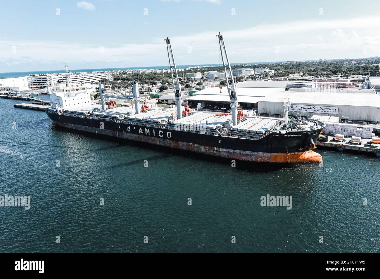 Large red Bulk ship / A coal ship docking outside big power station ...