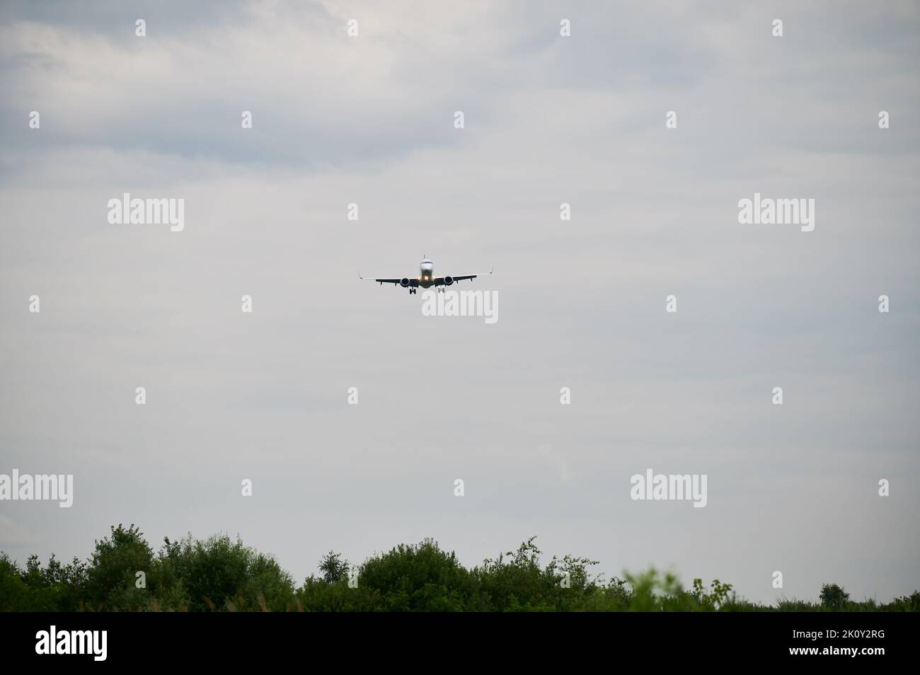 Commercial airplane flying in the sky. Front view of airliner landing ...