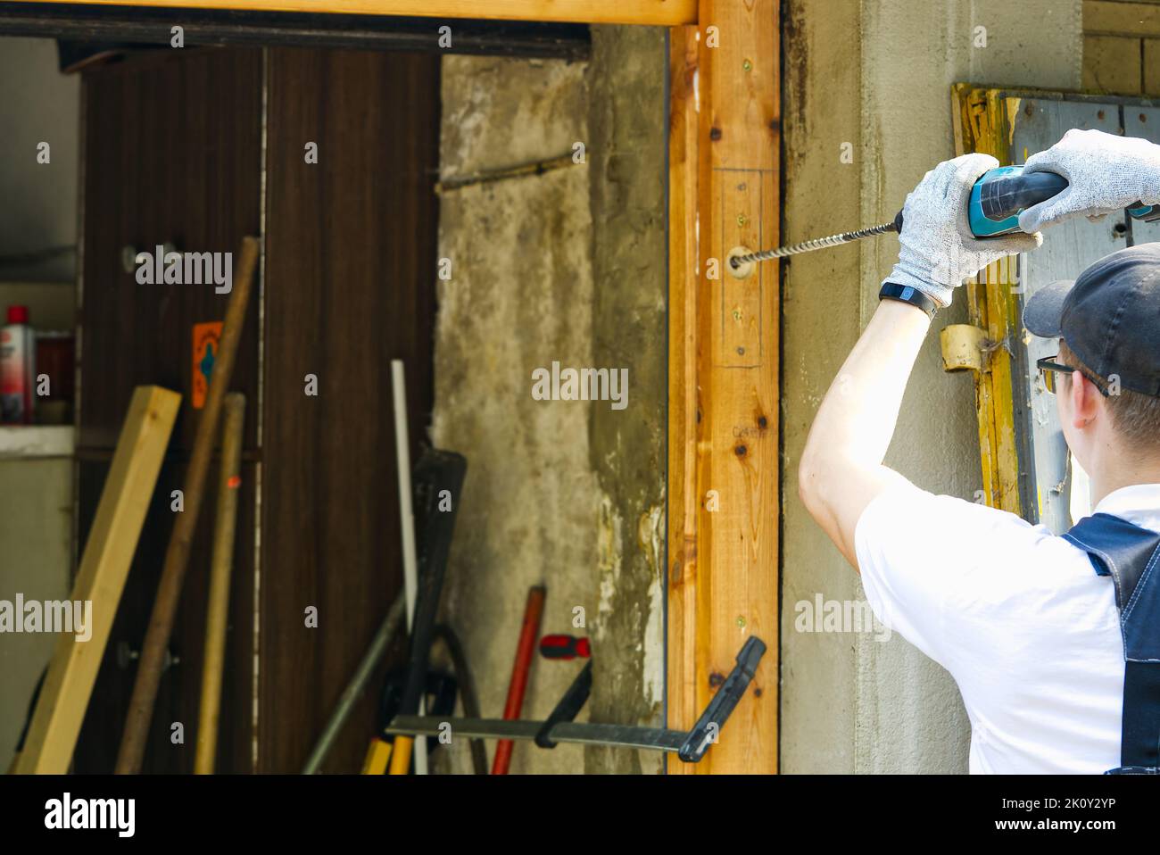 young master repairing old garage doors. handyman repairing a rotten ...