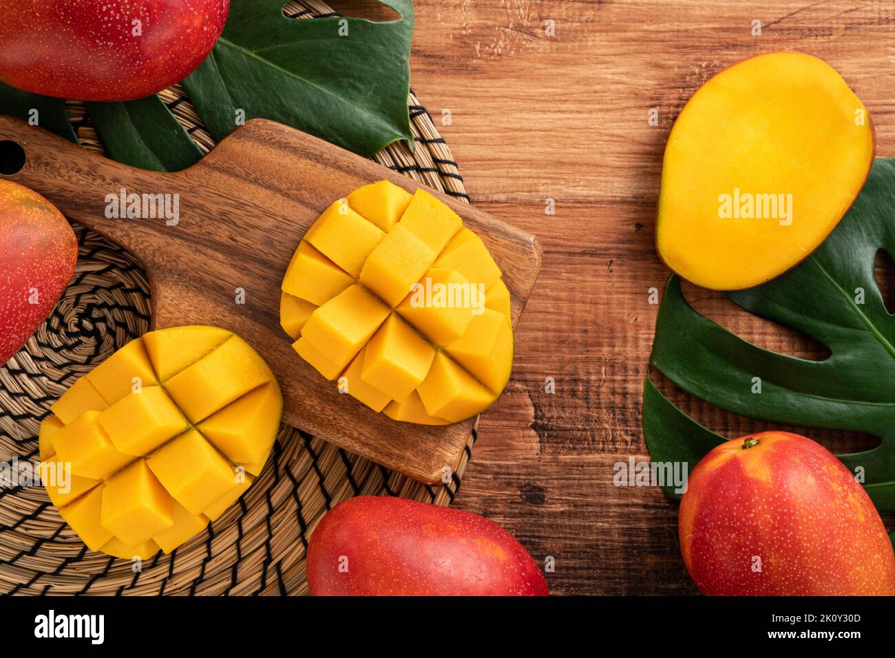 Top view of fresh ripe mango fruit with leaves over dark wooden table ...
