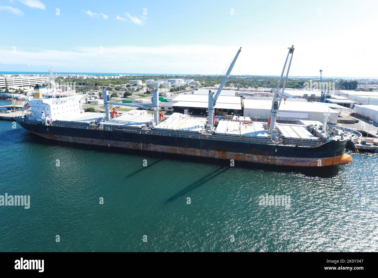 Large red Bulk ship / A coal ship docking outside big power station ...