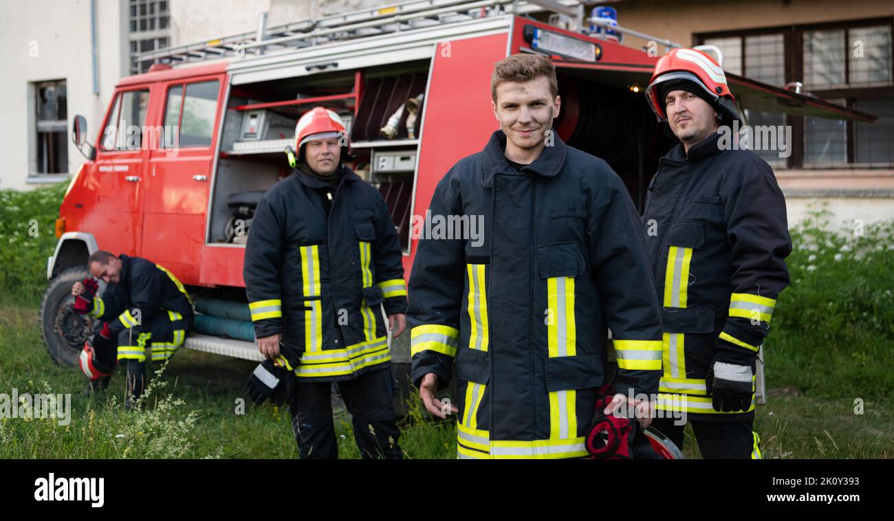 Group of fire fighters standing confident after a well done rescue ...