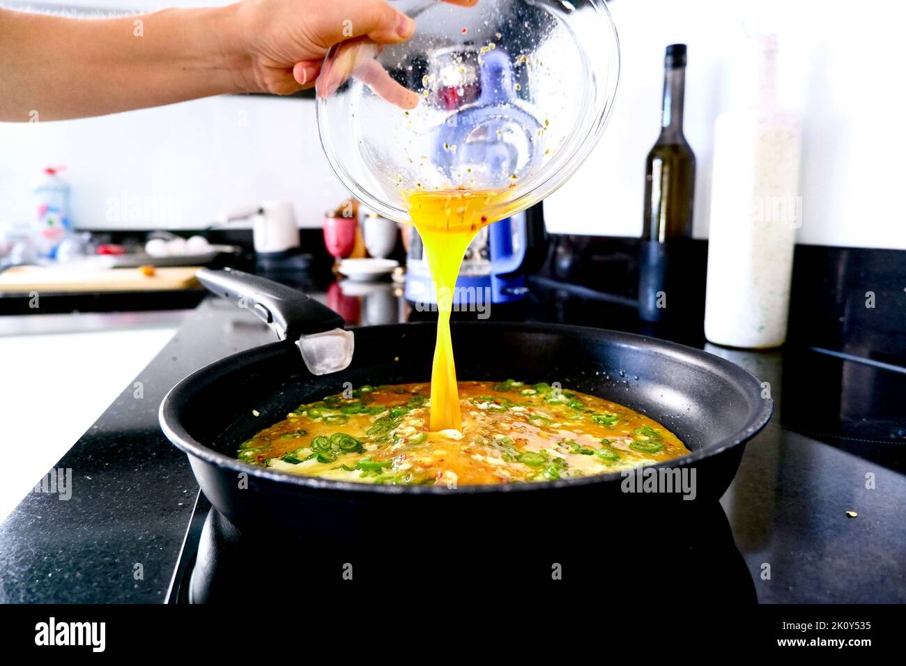 egg pouring into pan , cooking eggs Stock Photo - Alamy