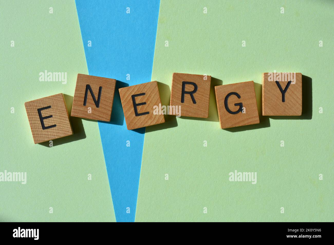 Energy, word in wooden alphabet letters isolated on green and blue ...