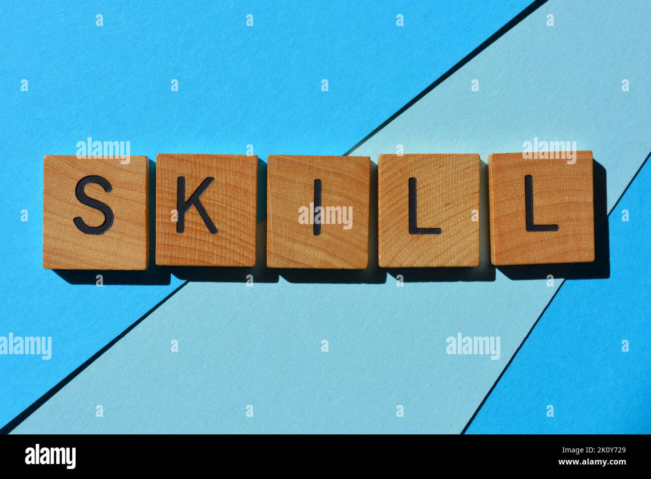 Skill, word in wooden alphabet letters isolated on blue background ...