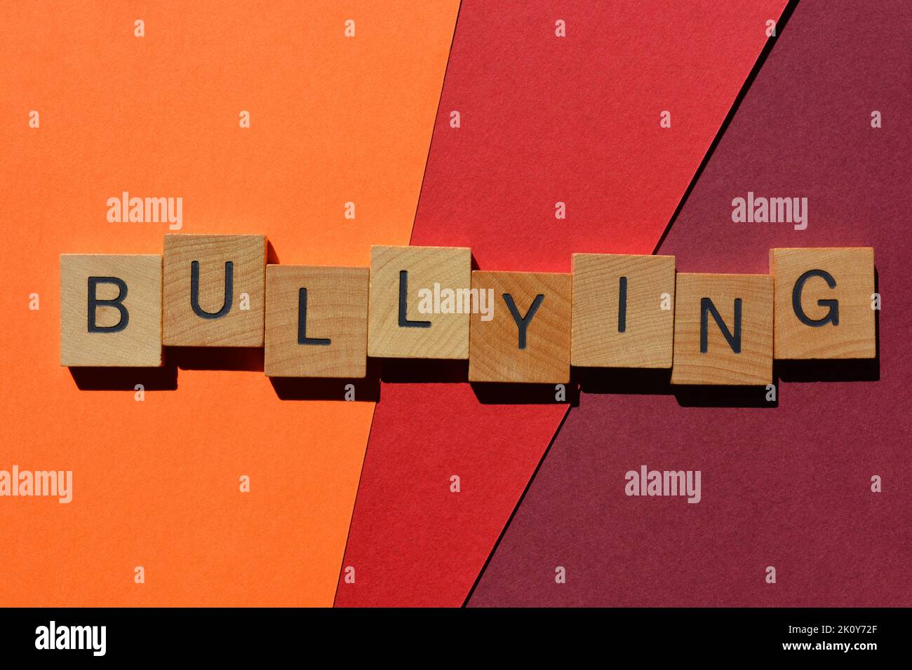 Bullying, word in wooden alphabet letters isolated on red and orange ...