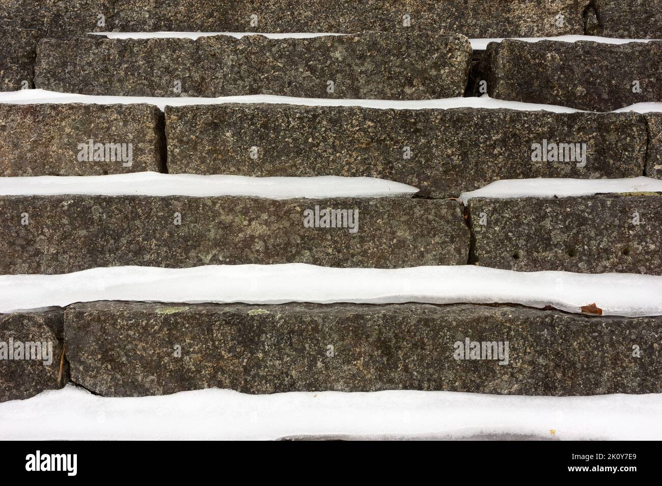 Close view of cut granite steps with late season snow covering the ...