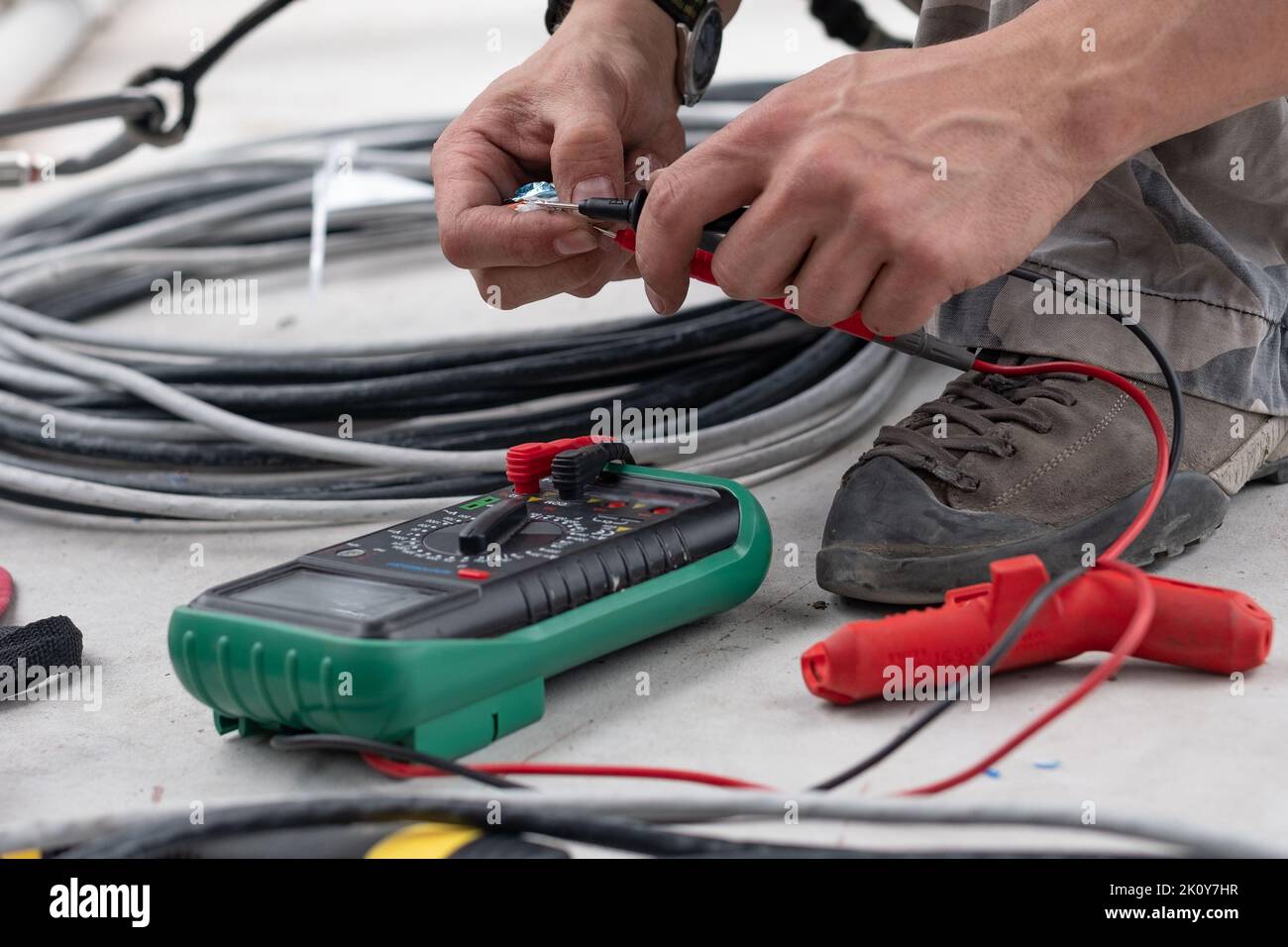 Close-up of an electrical engineer's hand ringing a cable with a ...