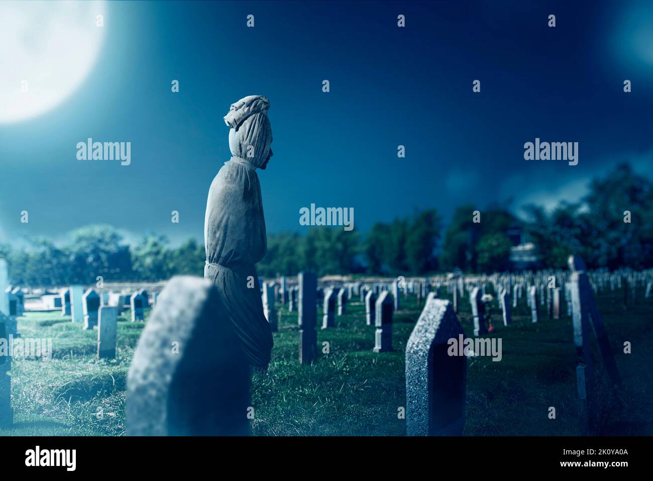Pocong is covered with a white linen shroud standing in the cemetery ...
