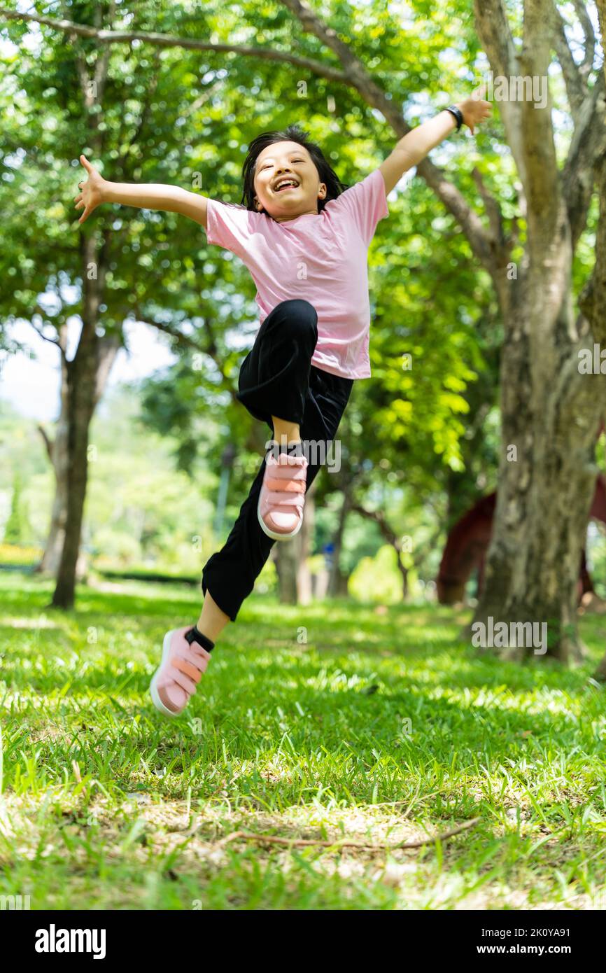 Portrait of child girl having fun jumping in the park outdoor Stock ...