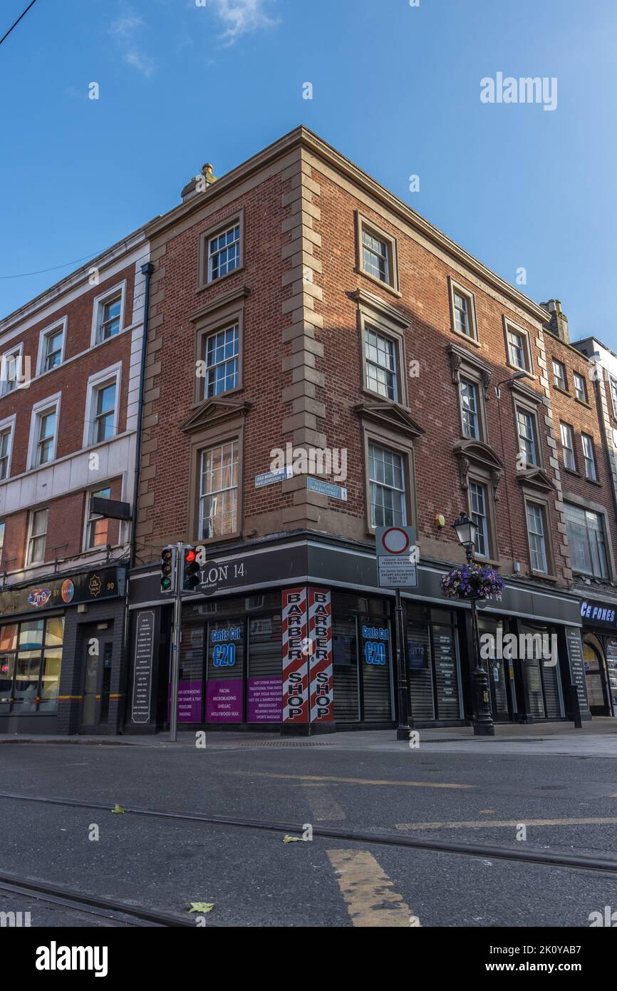 A corner street with brick buildings in the city of Dublin and traffic ...