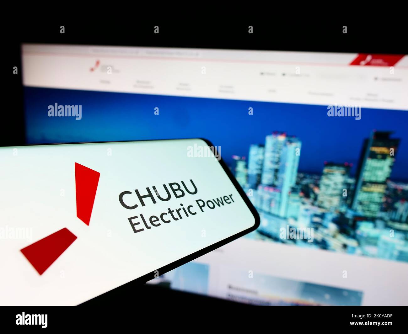 Cellphone with logo of Japanese company Chubu Electric Power Co. Inc. on screen in front of ...