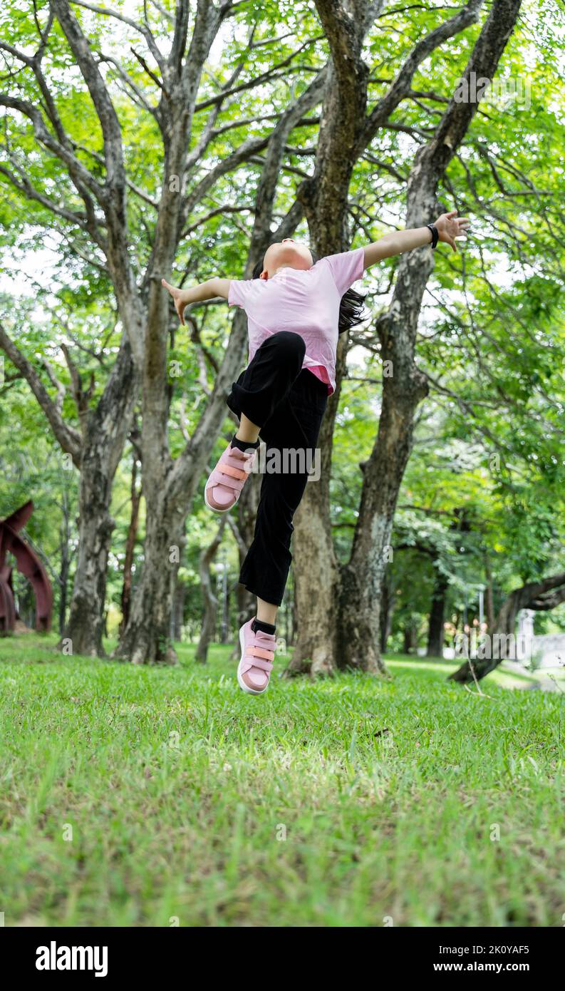 Portrait of child girl having fun jumping in the park outdoor Stock ...