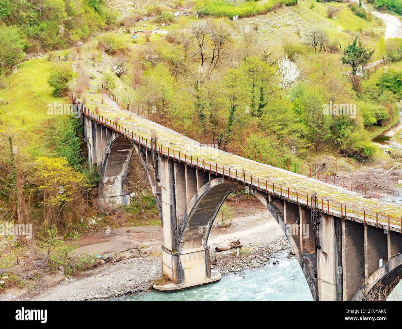 High abandoned bridge over the river. Old big bridge over the river in ...