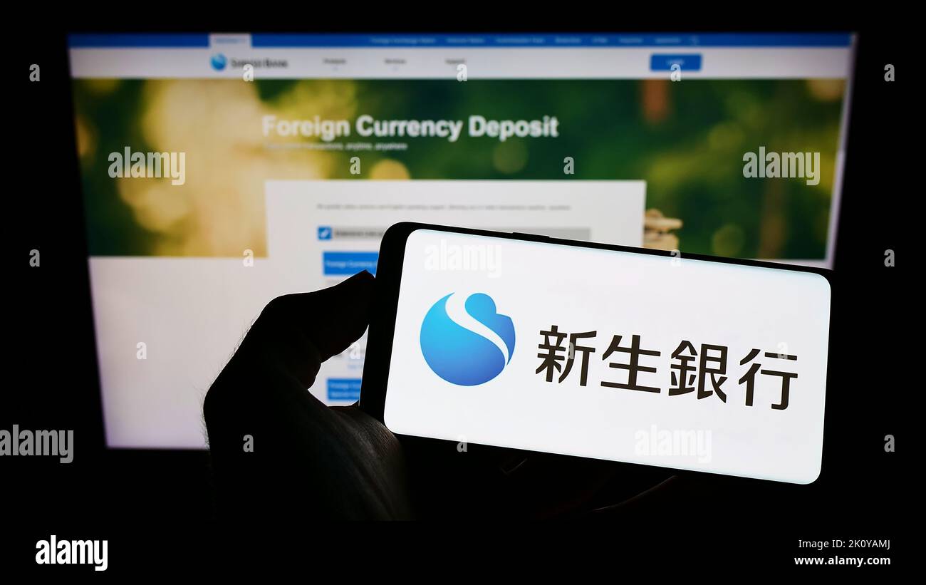 Person holding cellphone with logo of Japanese financial company ...