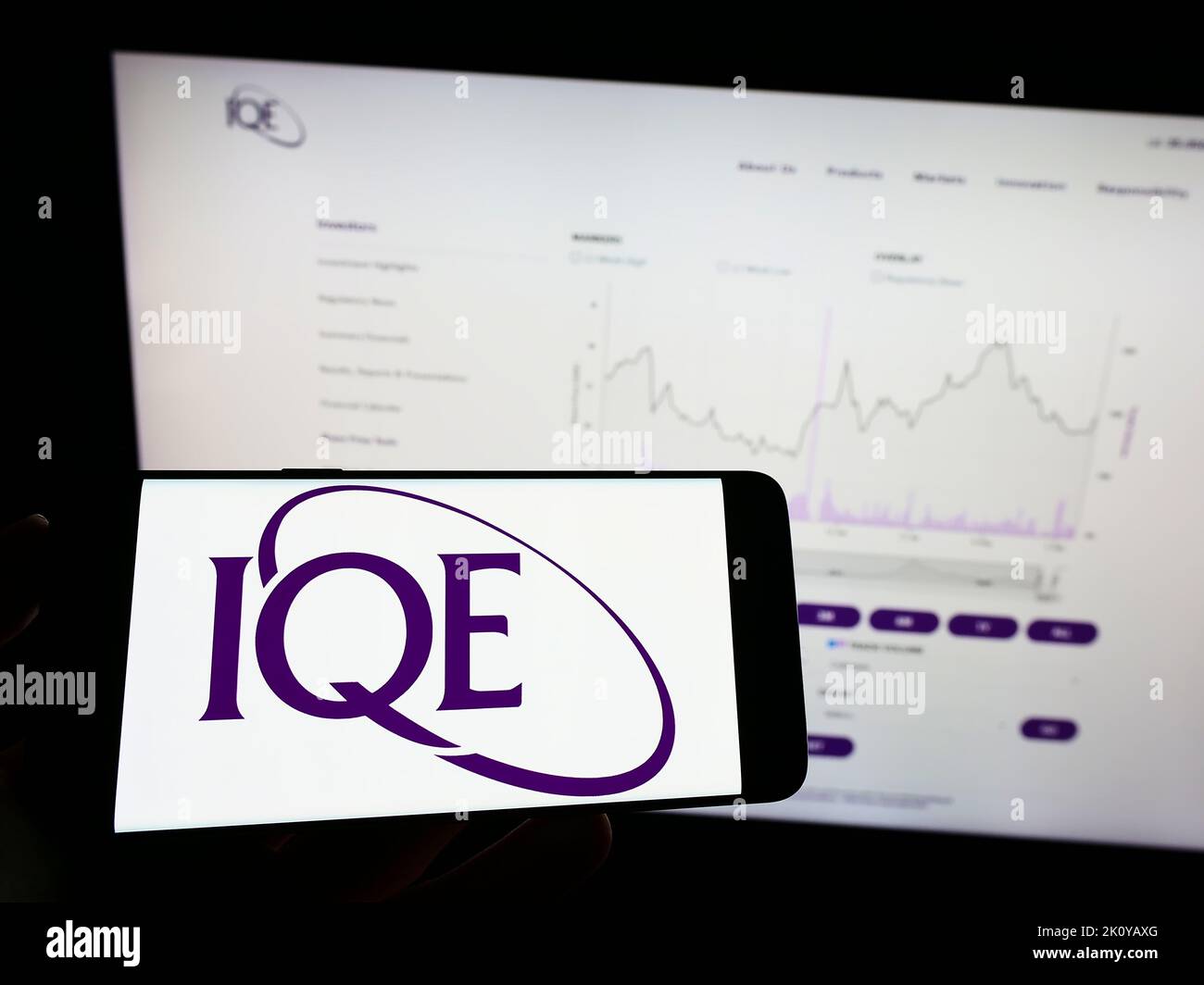 Person holding mobile phone with logo of British semiconductor company ...