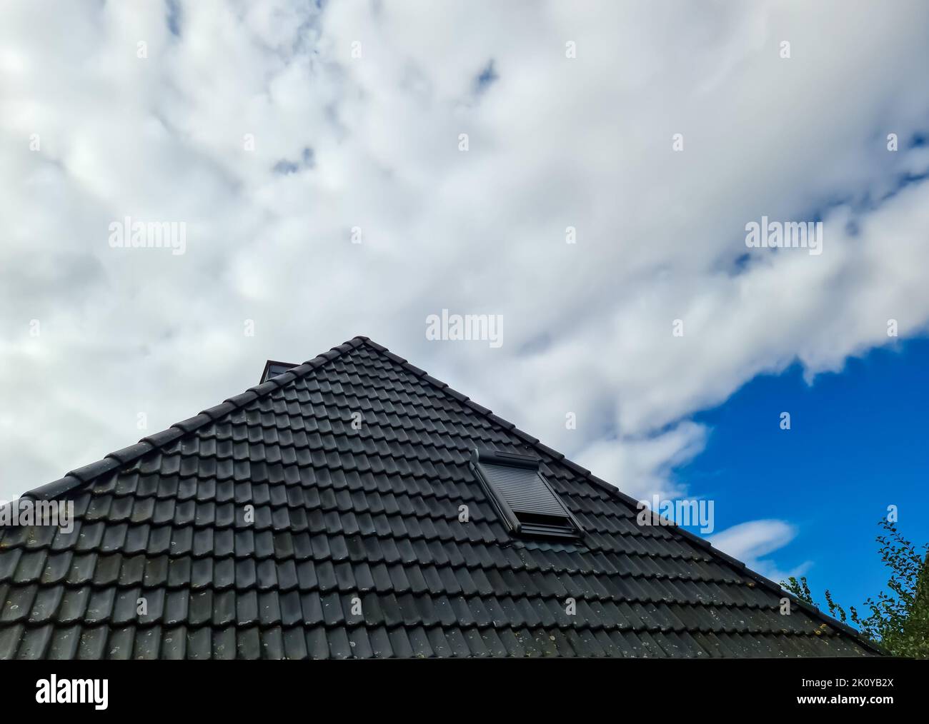 Open roof window in velux style with black roof tiles Stock Photo - Alamy