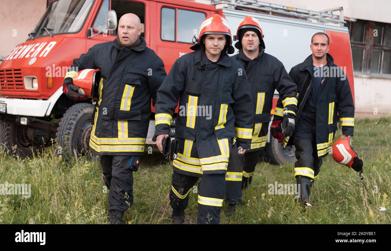 Group of fire fighters standing confident after a well done rescue ...