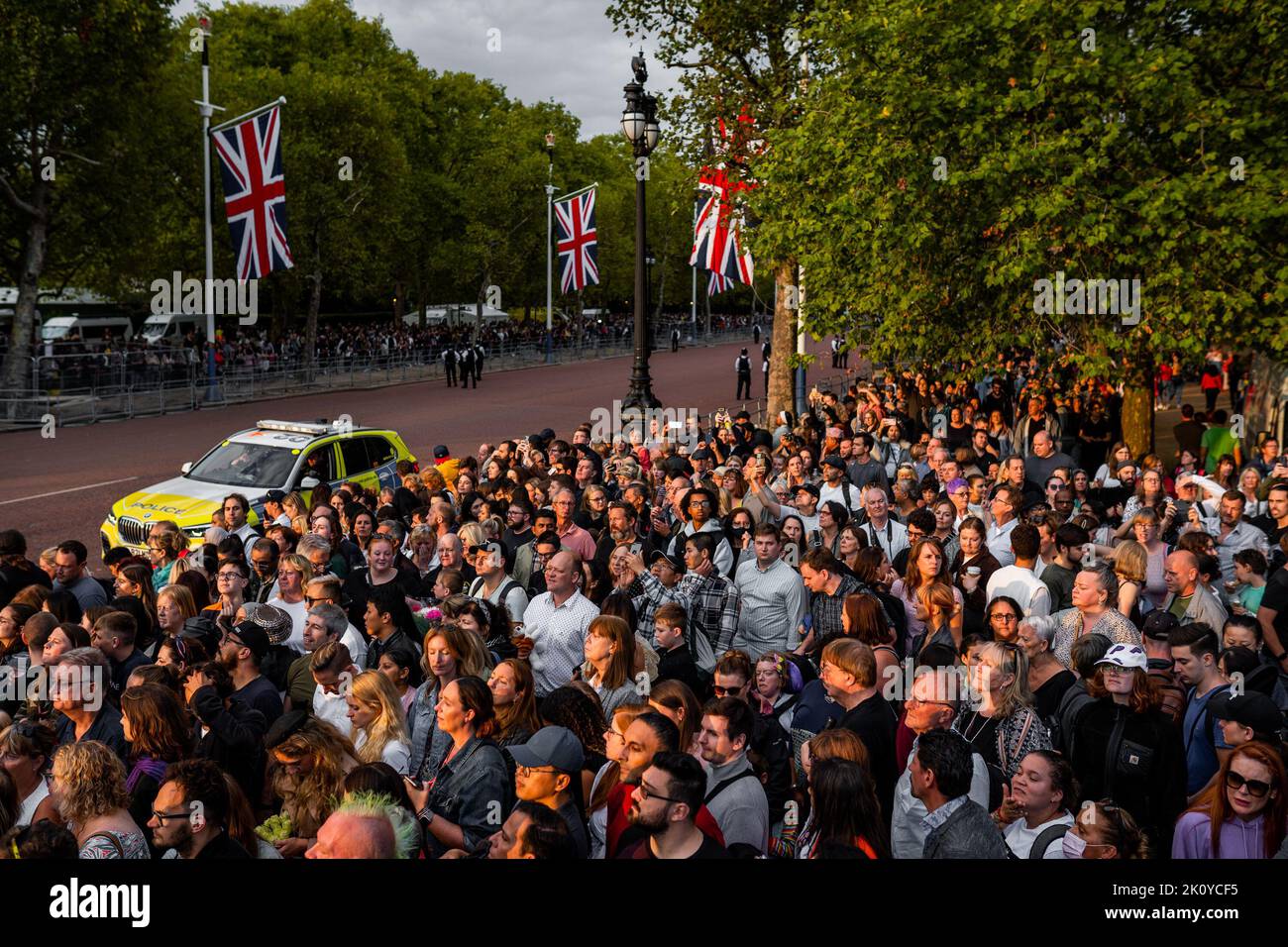 People watch the sunset at Buckingham Palace after the first full day ...