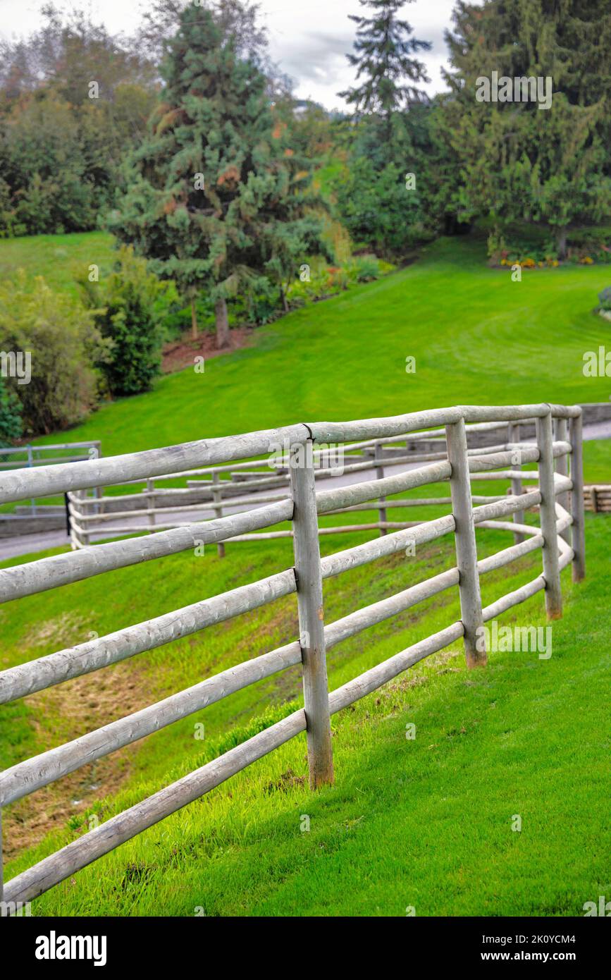 Wood log fence on green fields background Stock Photo - Alamy