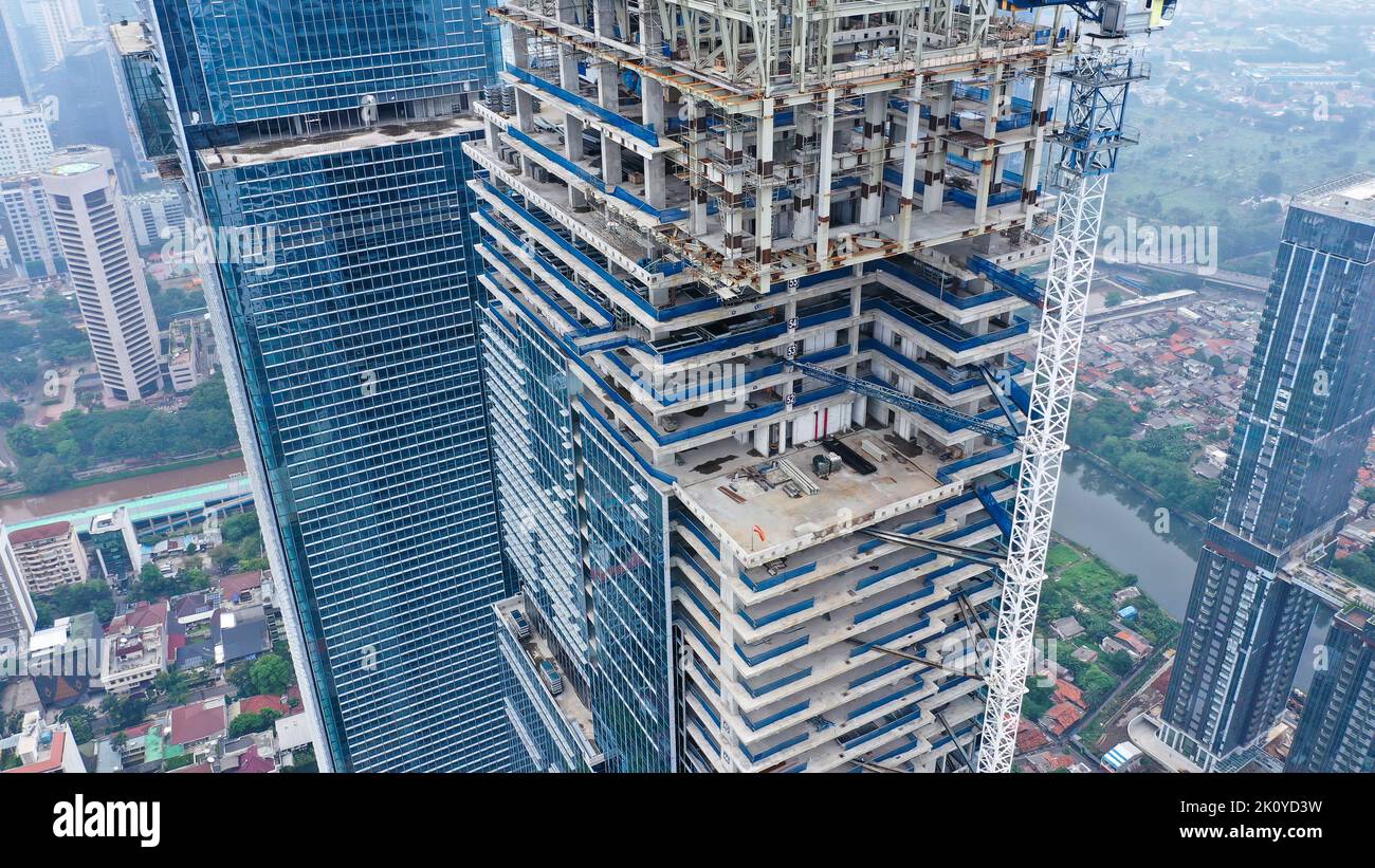 Skyscraper under construction, with crane on top, for urban and ...
