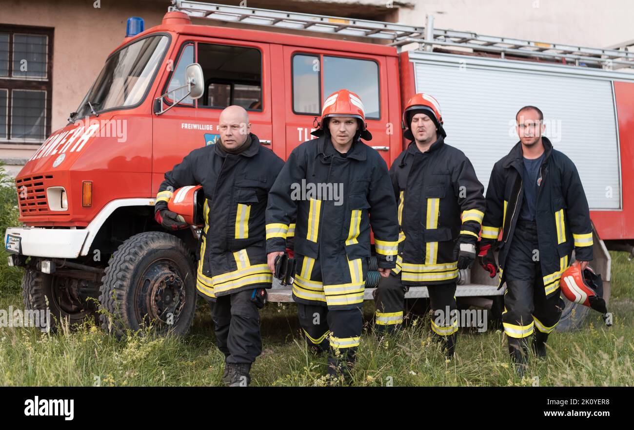 Group of fire fighters standing confident after a well done rescue ...