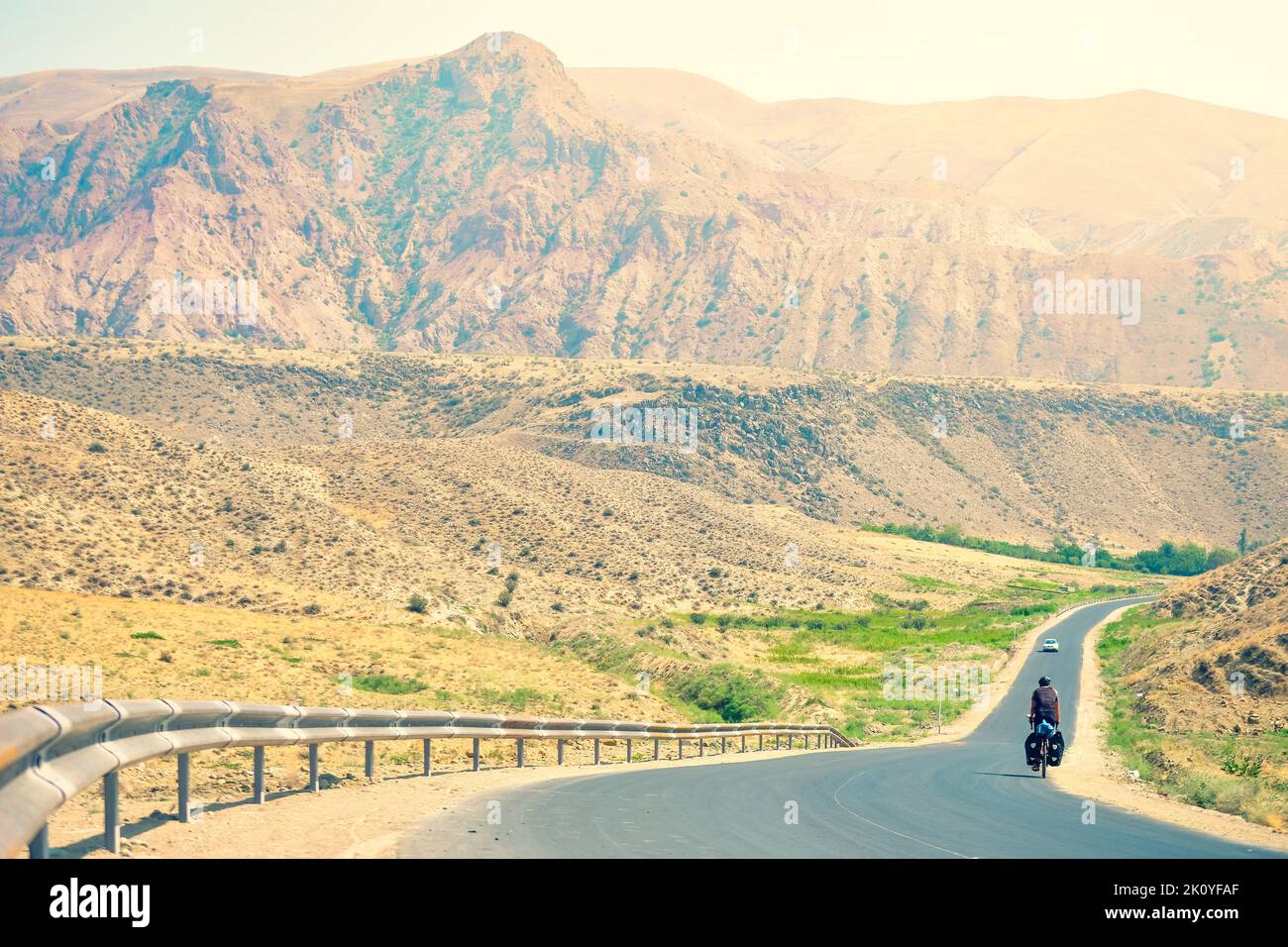 Scenic landscape back view of male cyclist solo touring in tranquil ...
