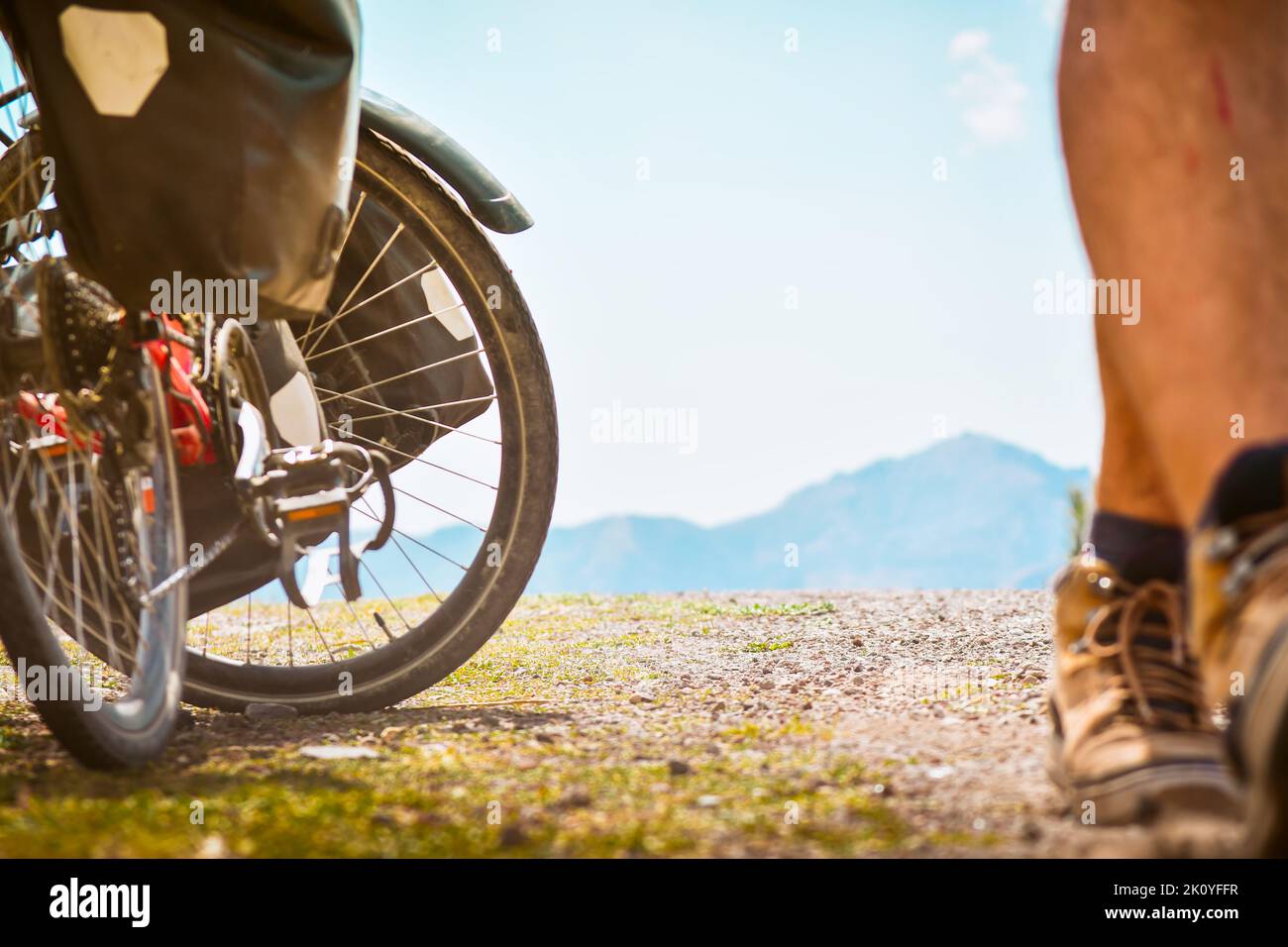 Close up tracking low angle back view of male cyclist walking towards ...