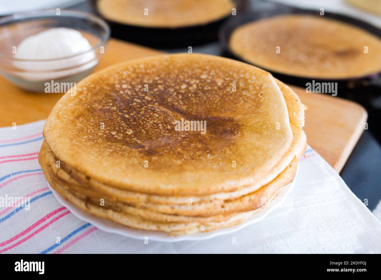 hot golden pancakes made from grain flour in kitchen while cooking on ...