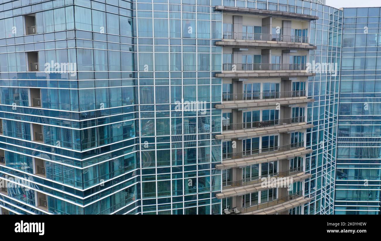 The glass facade of a skyscraper with a mirror reflection of sky ...
