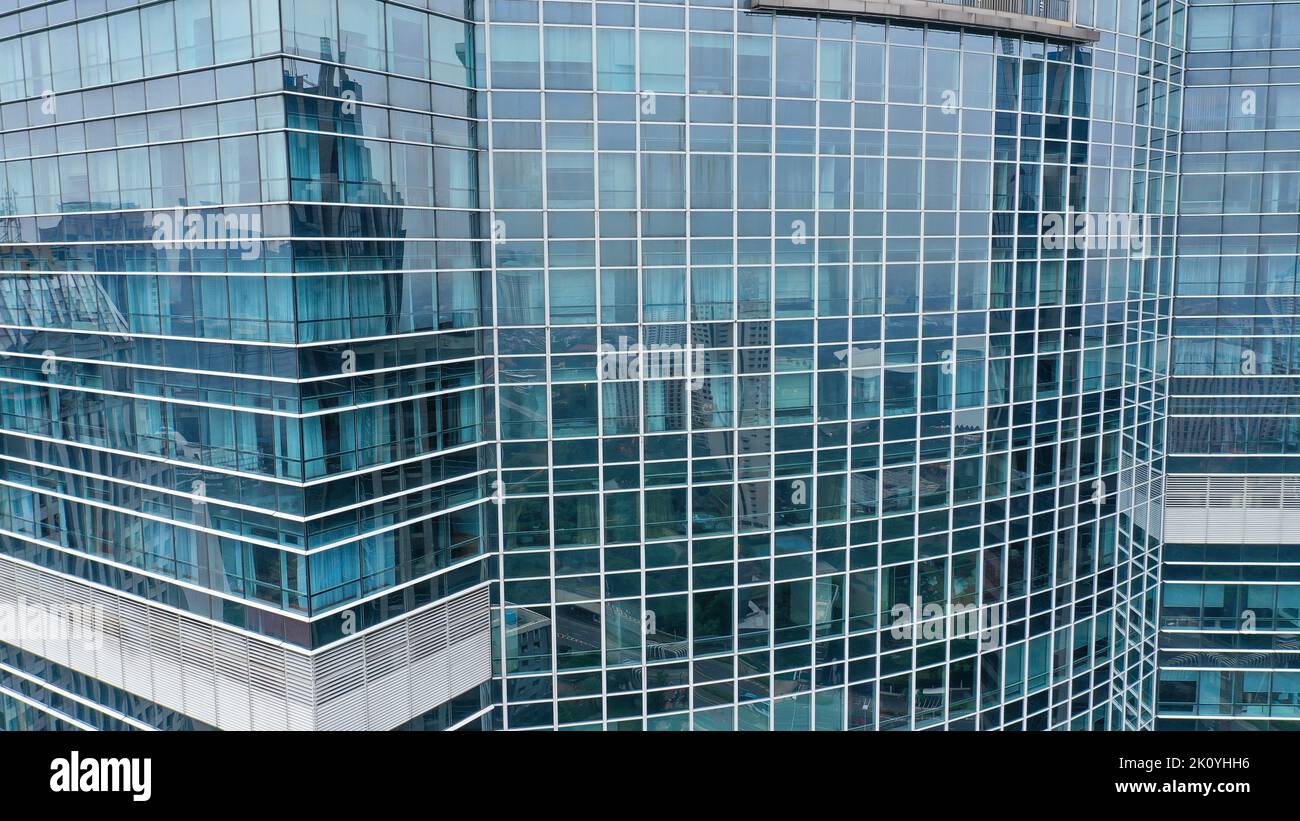 The glass facade of a skyscraper with a mirror reflection of sky ...