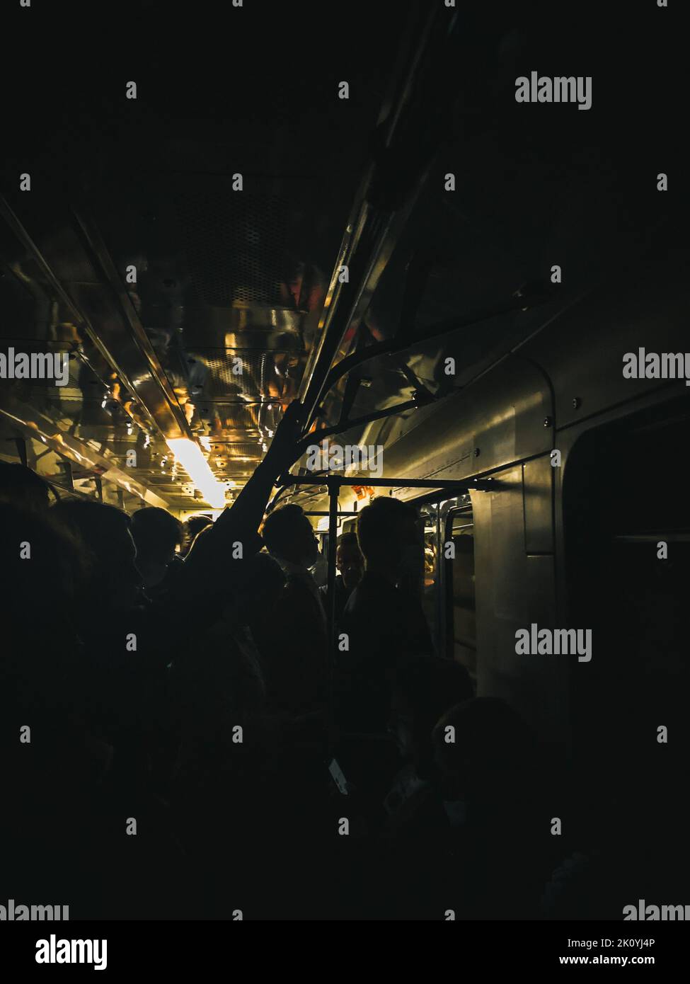 A silhouette shot of people standing inside the train Stock Photo - Alamy