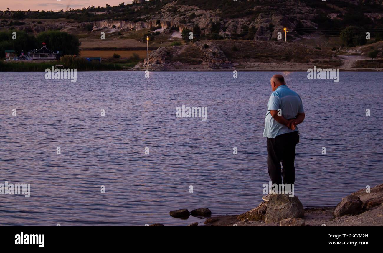 Sad man standing alone by the lake. Depression concept photo. Selective ...
