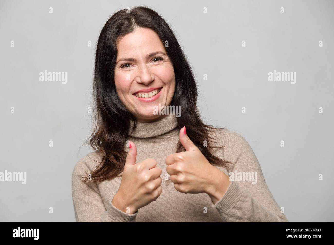 portrait of a woman showing thumbs-up gesture with both hands Stock ...