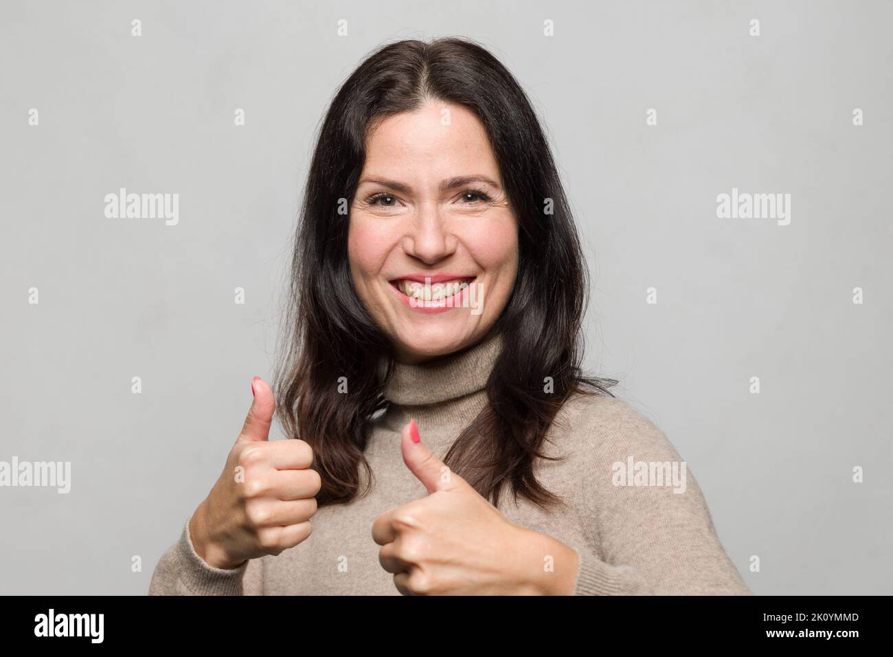 portrait of a woman showing thumbs-up gesture with both hands Stock ...
