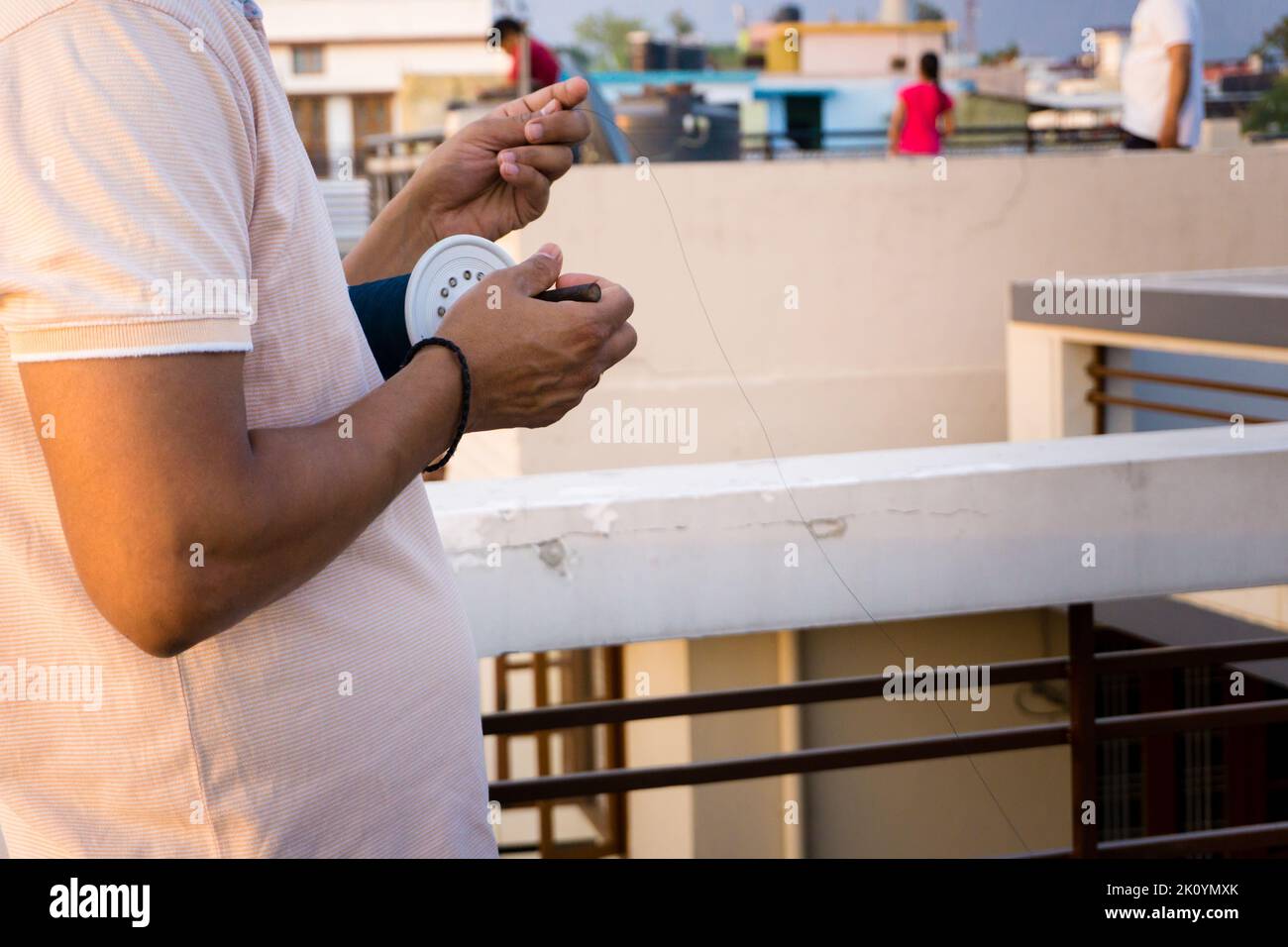 A close up shot of a man with a kite spool with thread and colorful ...