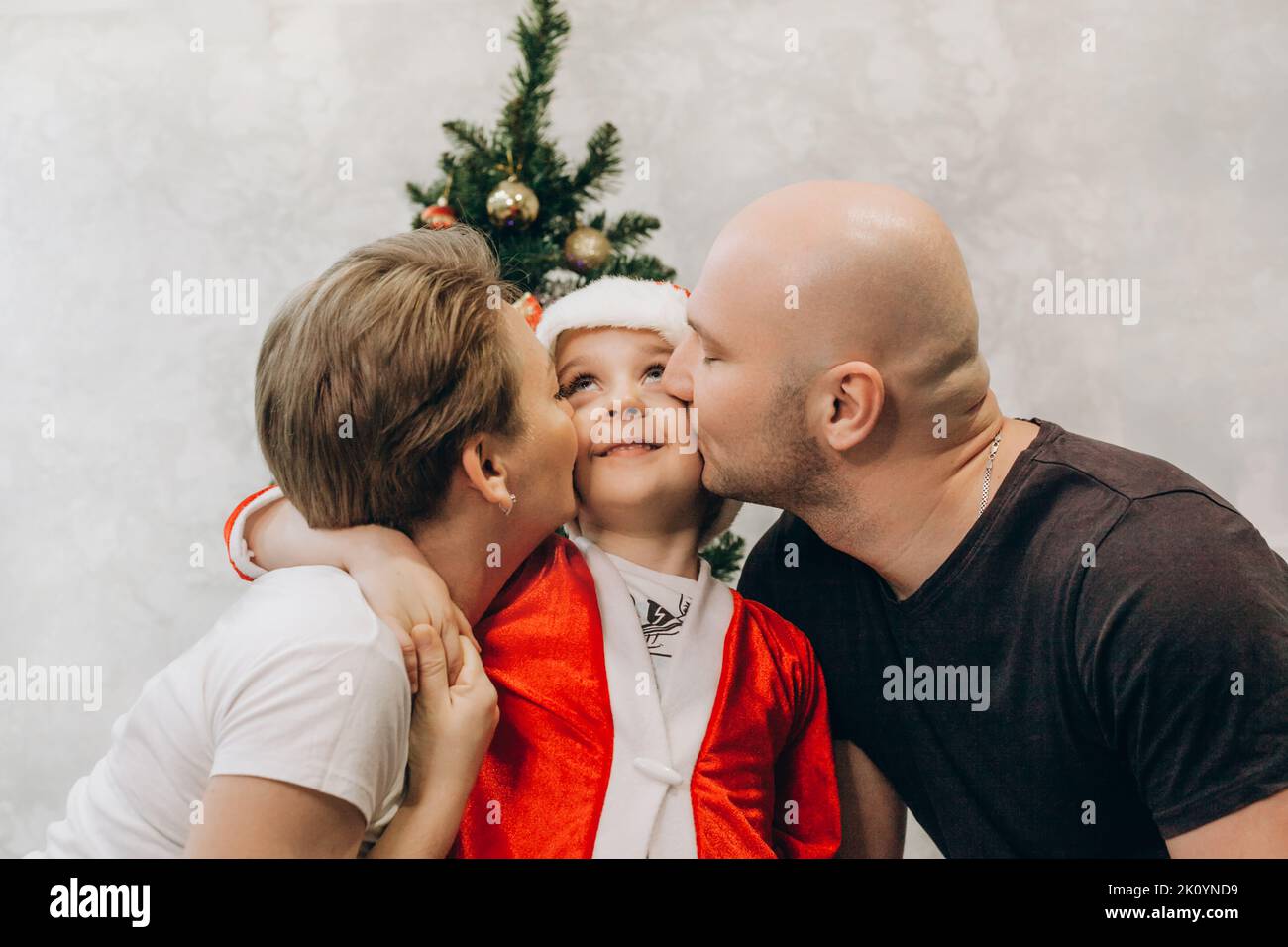 Family mom, dad and son in Santa costume are standing near the ...