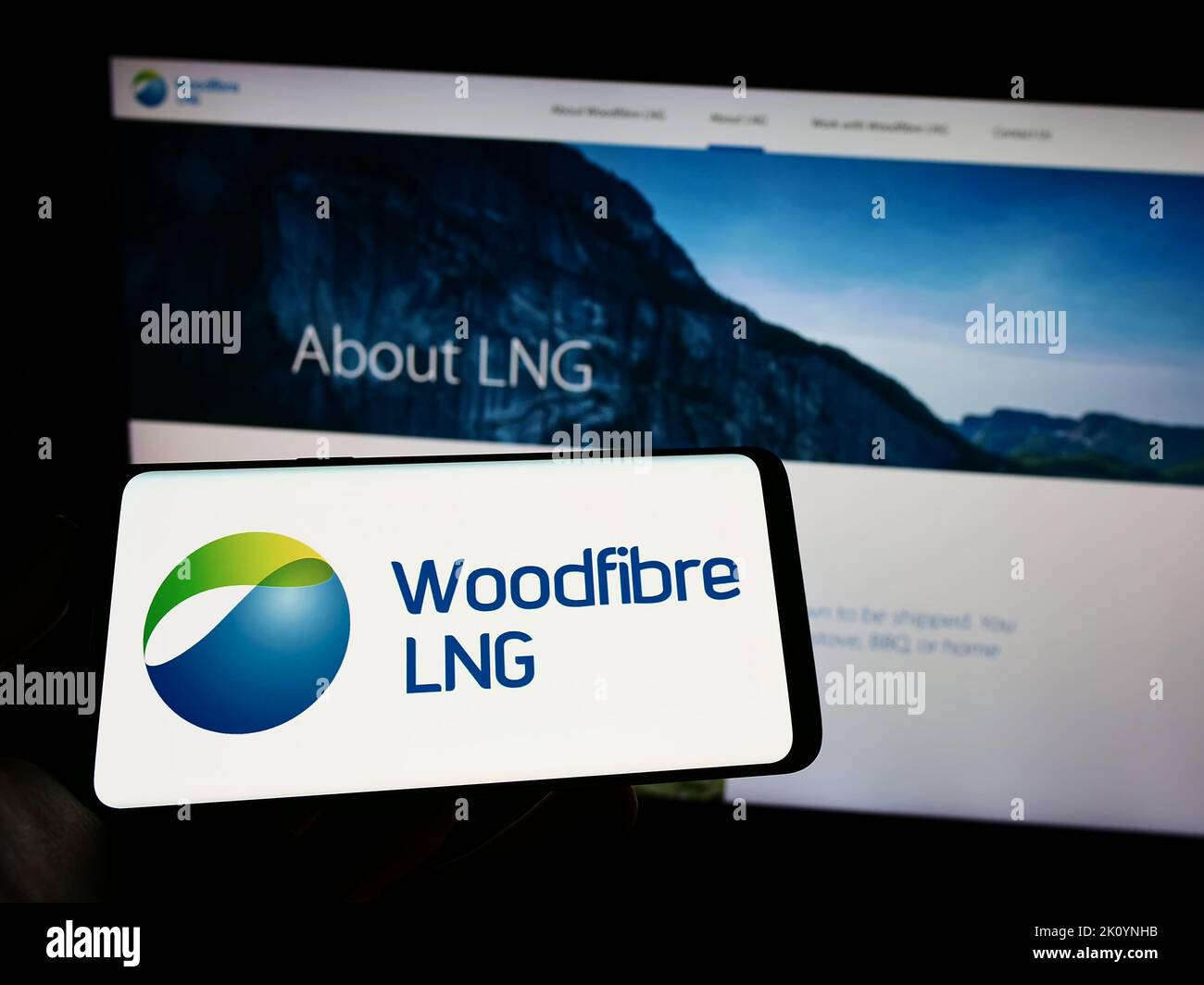 Person holding cellphone with logo of Canadian gas company Woodfibre ...