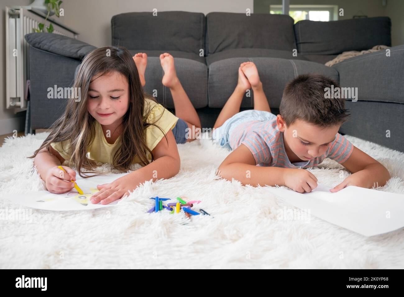 Siblings playing together at home. little boy and girl lying on the ...