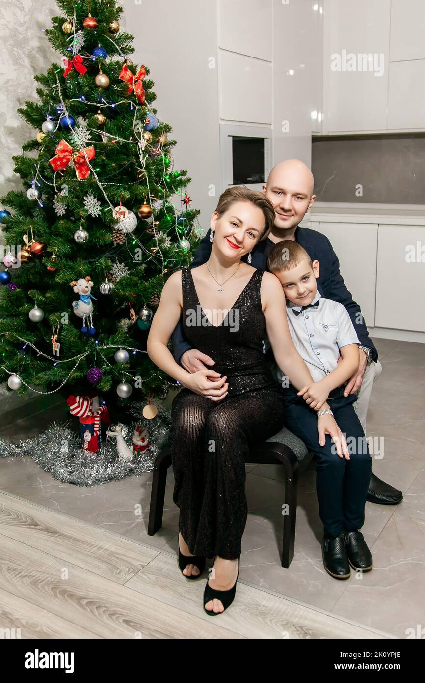 Family - mom, dad and son in smart clothes are sitting next to the ...