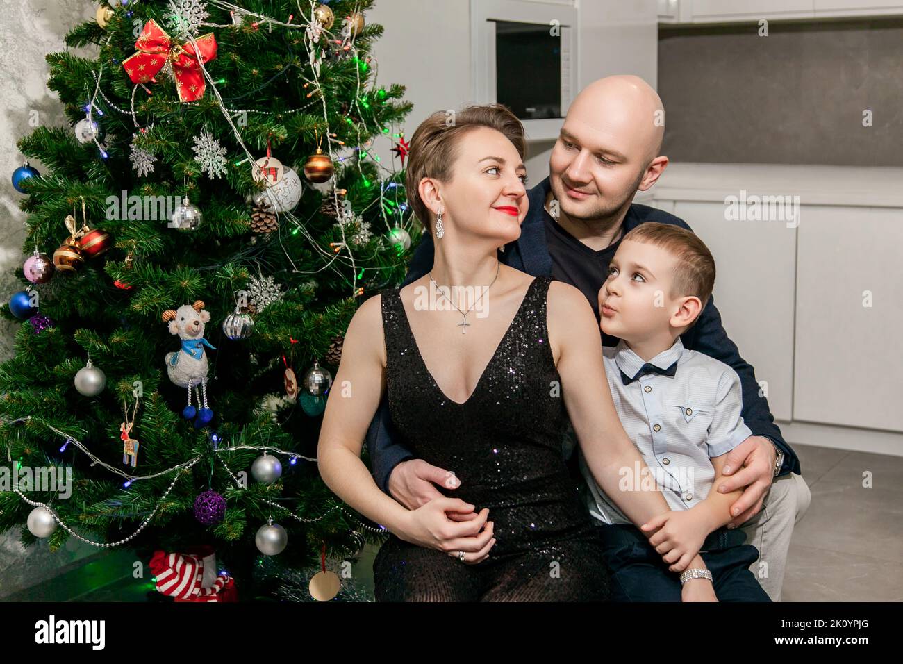 Family - mom, dad and son in smart clothes sitting next to the ...