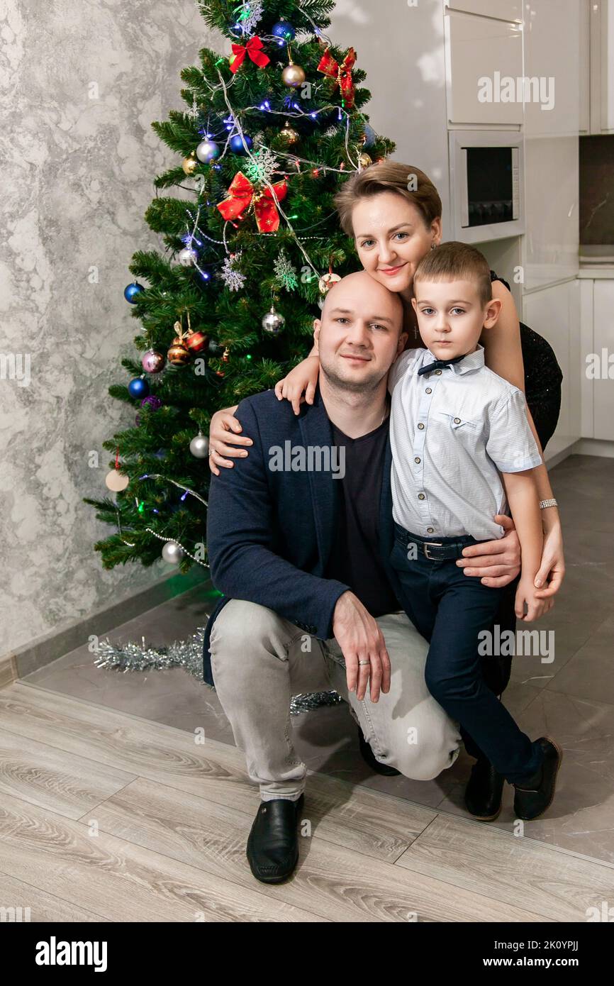 Family - mom, dad and son in smart clothes are sitting next to the ...