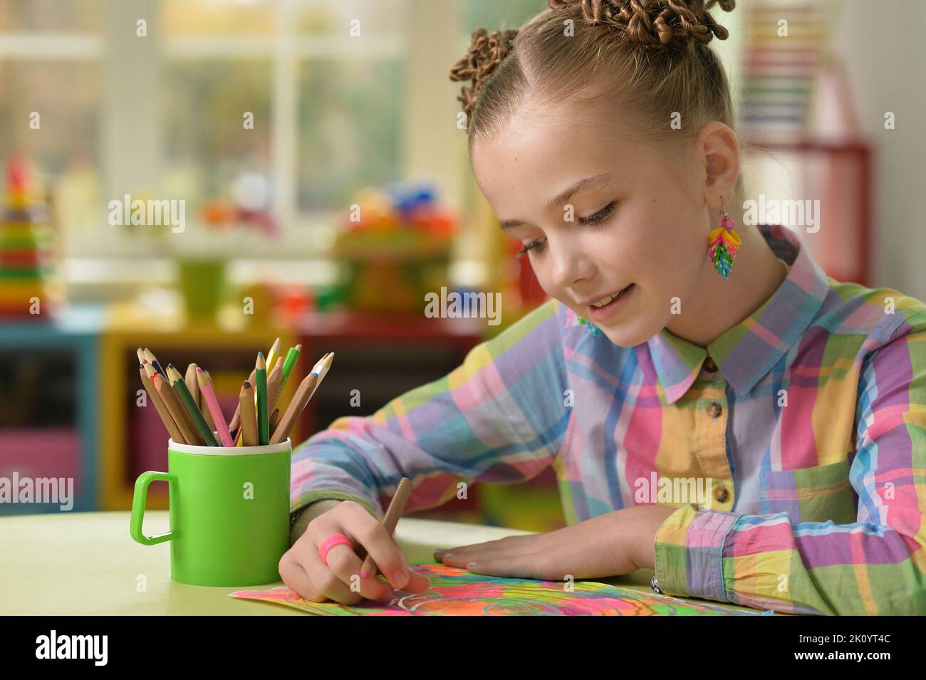 Beautiful little girl draws with a pencil on a sheet of paper Stock ...