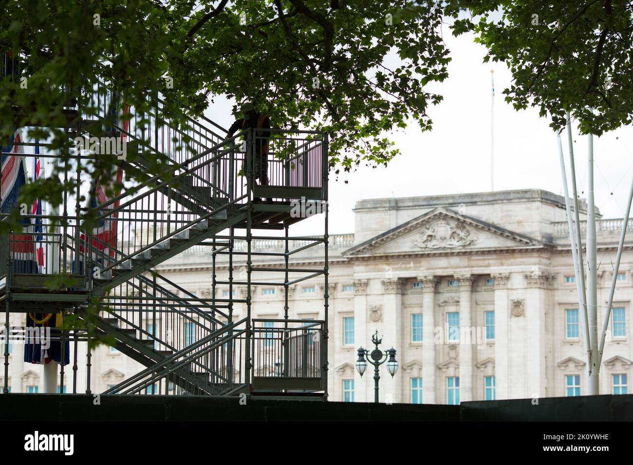 Temporary structures and workers are silhouetted against Buckingham ...
