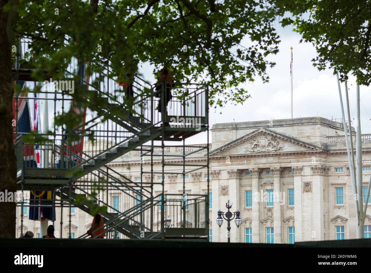 Temporary structures and workers are silhouetted against Buckingham ...