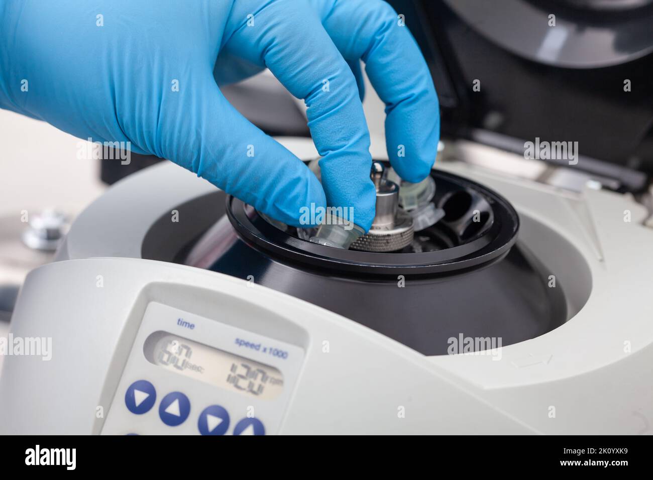 Closeup of a scientist hand placing a tube into an small table ...