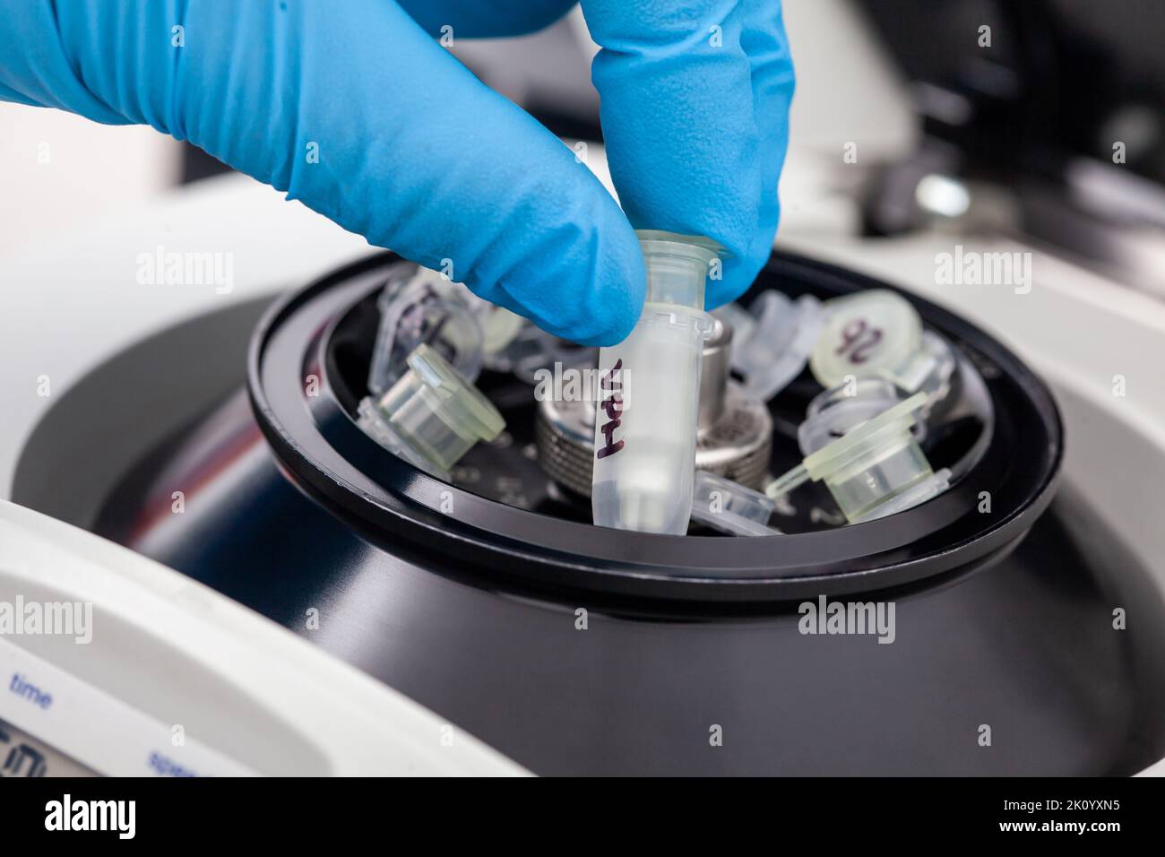 Closeup of a scientist hand placing a tube into an small table ...