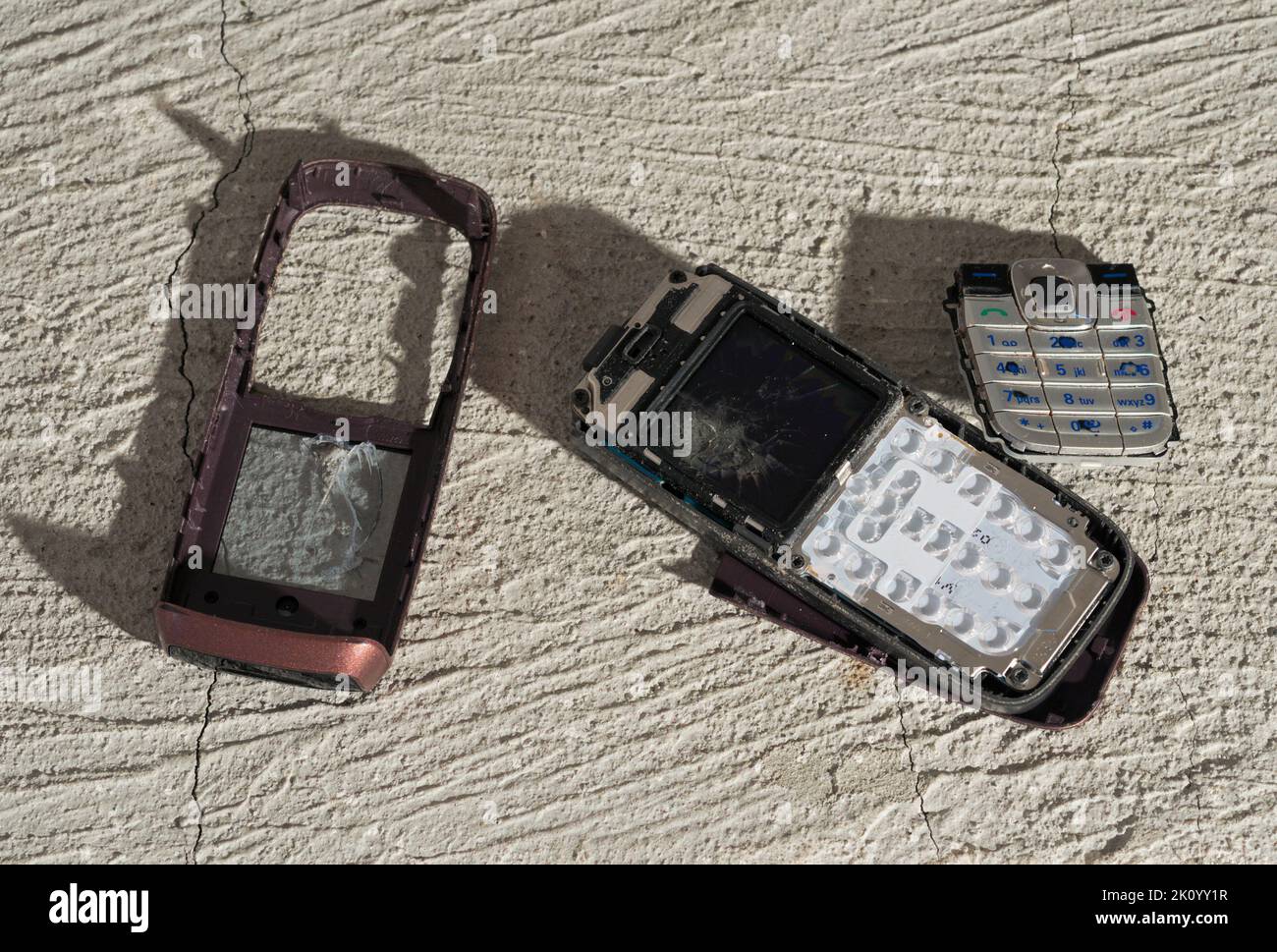 parts of a smashed cellphone on concrete ground Stock Photo - Alamy